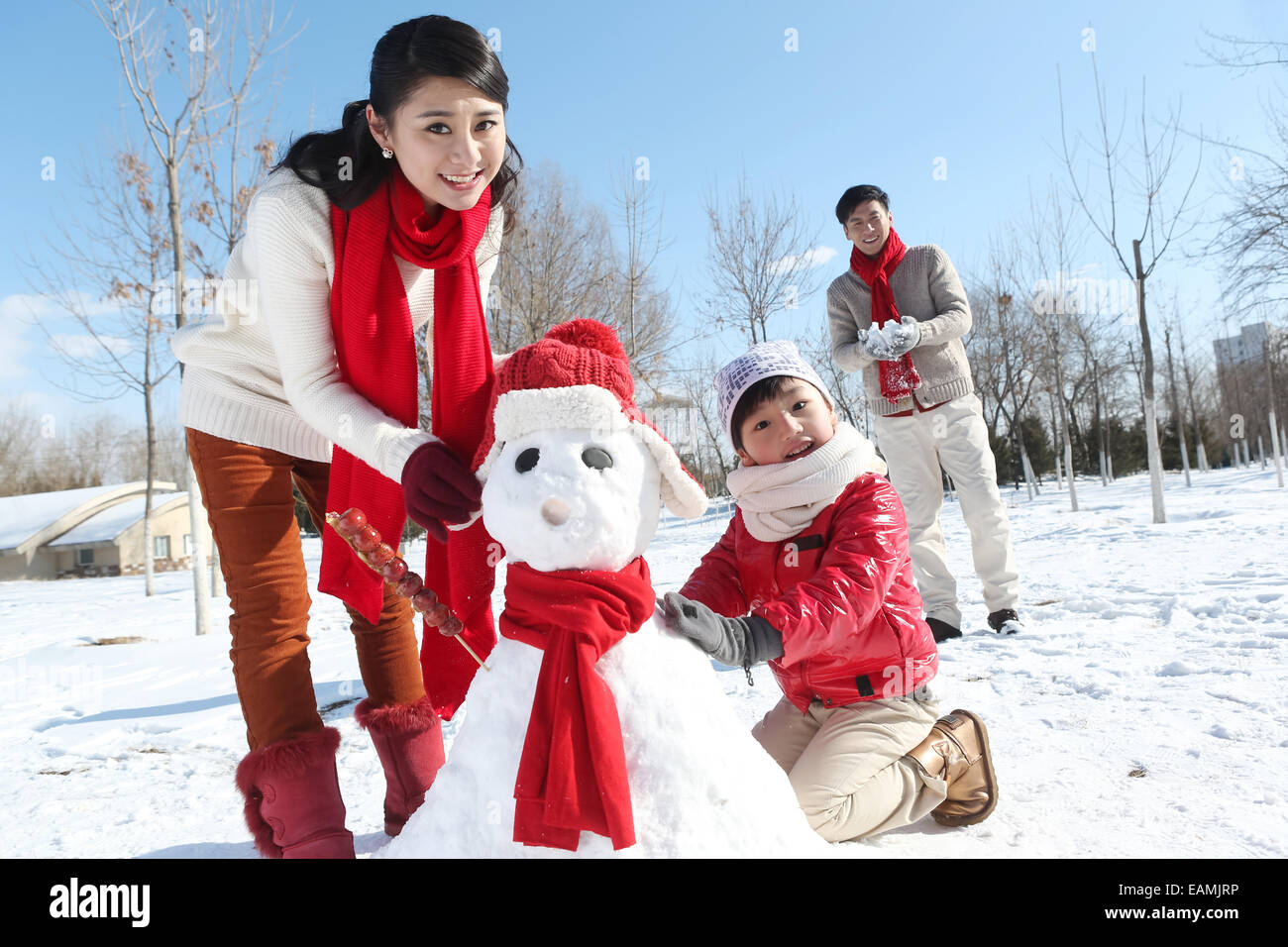 A family of three make a snowman in the outdoor Stock Photo - Alamy