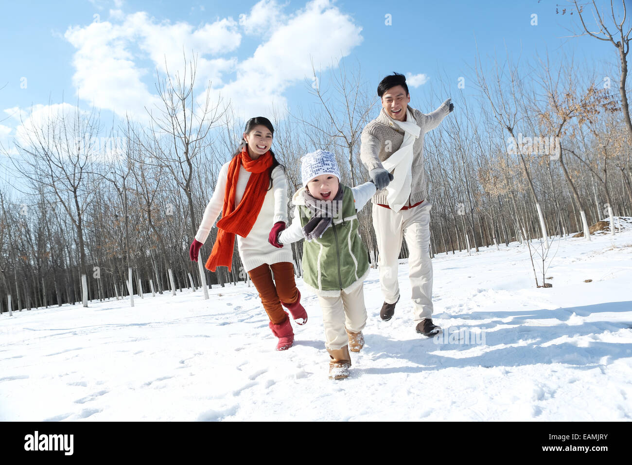 A family of three running in the snow Stock Photo - Alamy