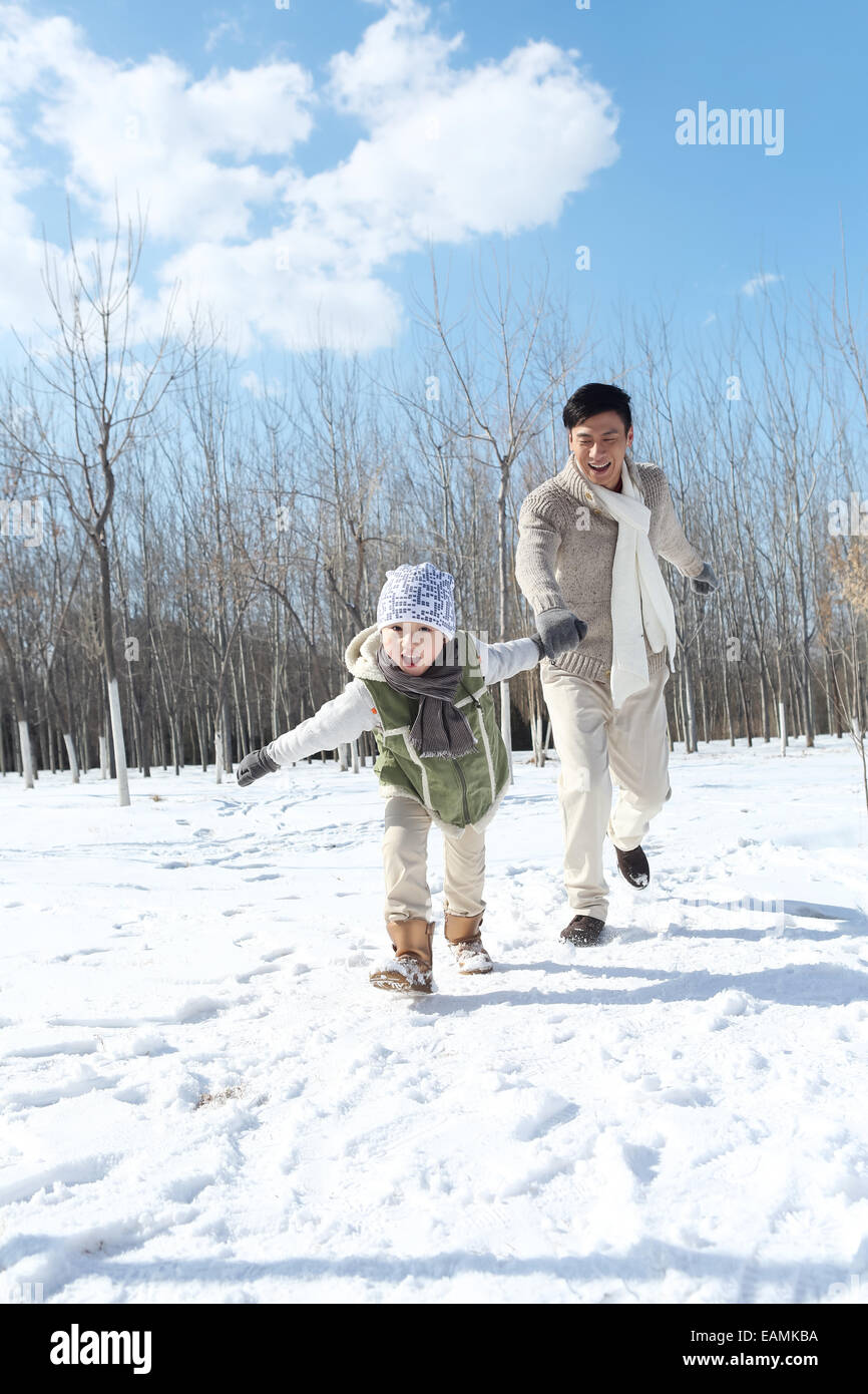 Father and son running in the snow Stock Photo - Alamy