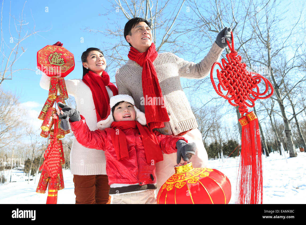 A family of three in the snow with New Year decoration Stock Photo - Alamy