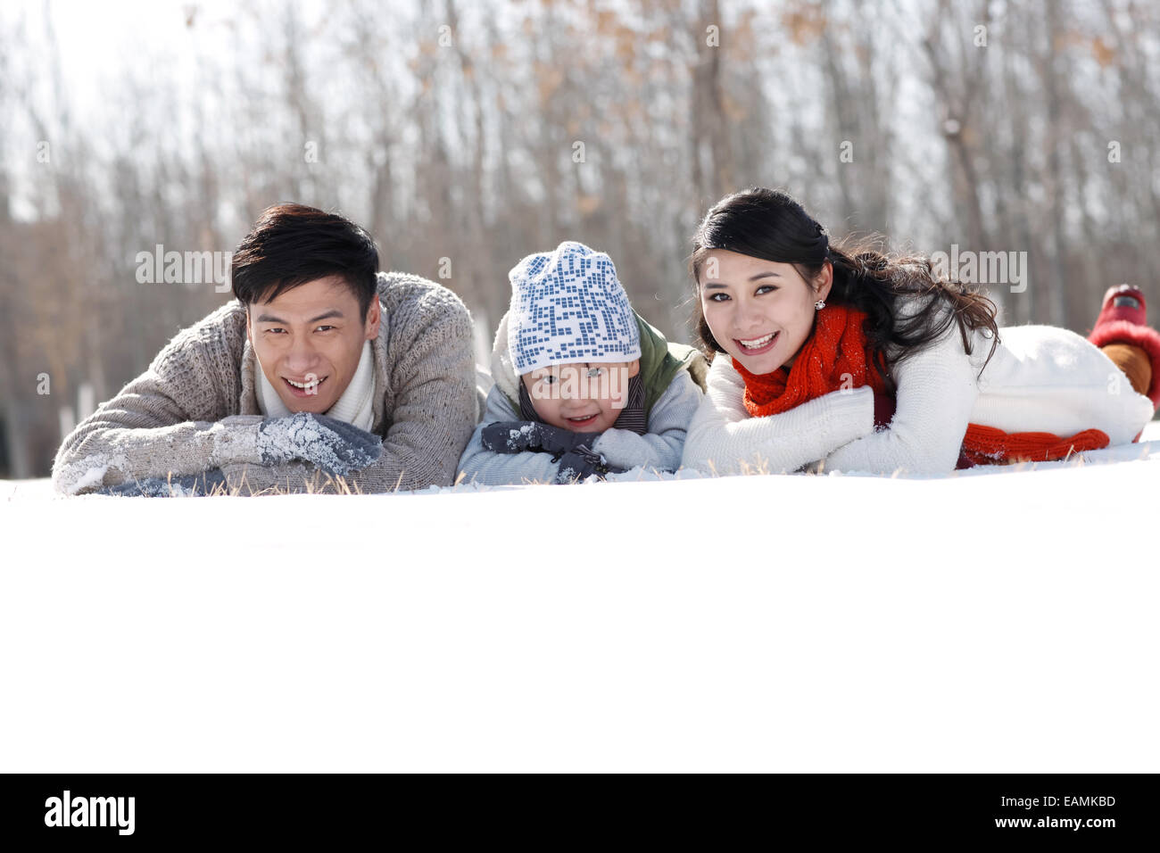 A family of three on playing in the snow Stock Photo - Alamy