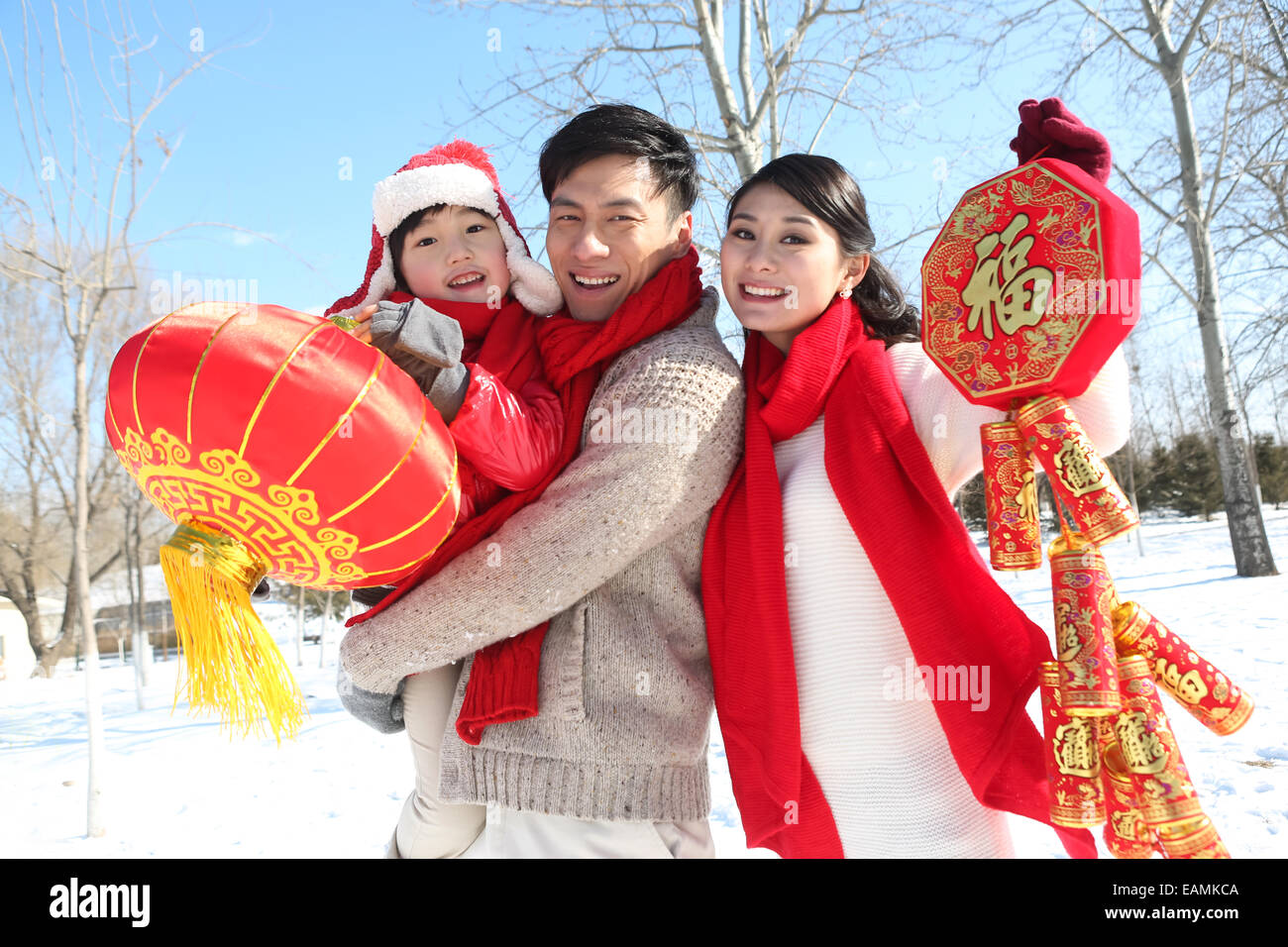 A family of three in the snow with New Year decoration Stock Photo - Alamy