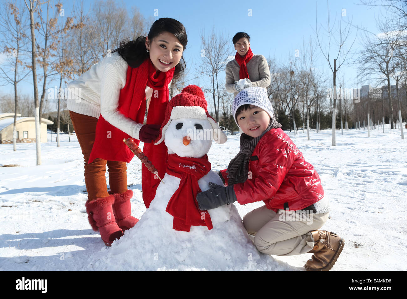 A family of three make a snowman in the outdoor Stock Photo - Alamy