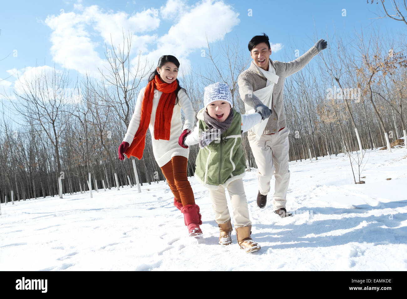 A family of three running in the snow Stock Photo - Alamy