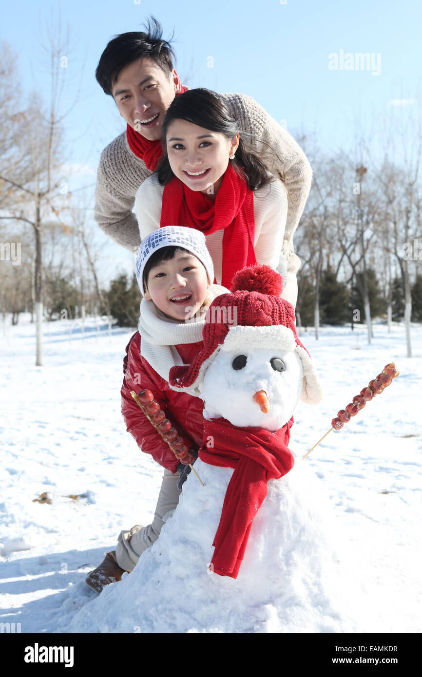 A family of three make a snowman in the outdoor Stock Photo - Alamy