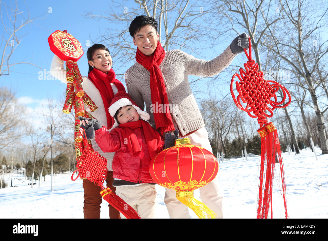 A family of three in the snow with New Year decoration Stock Photo - Alamy