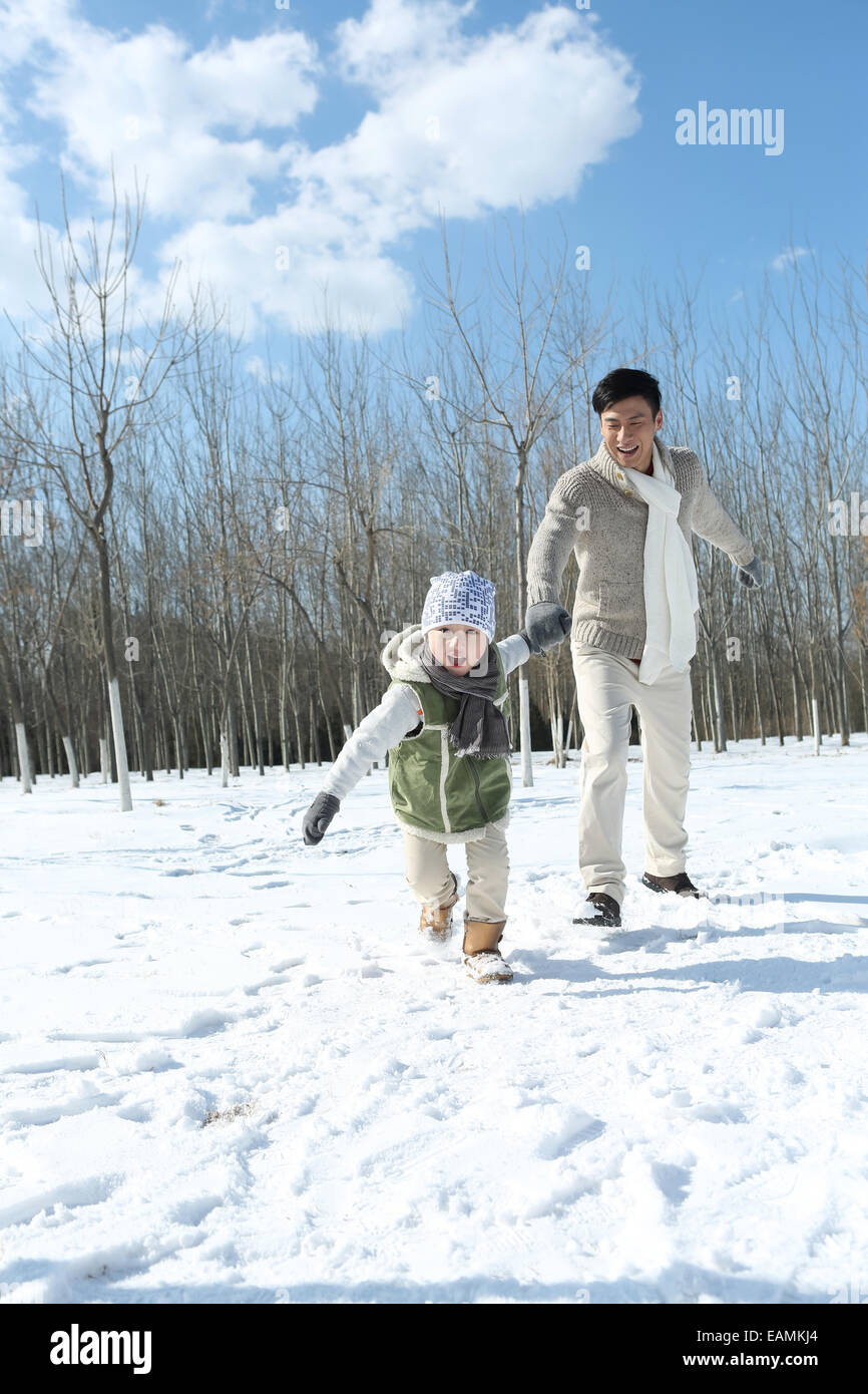 Father and son running in the snow Stock Photo - Alamy