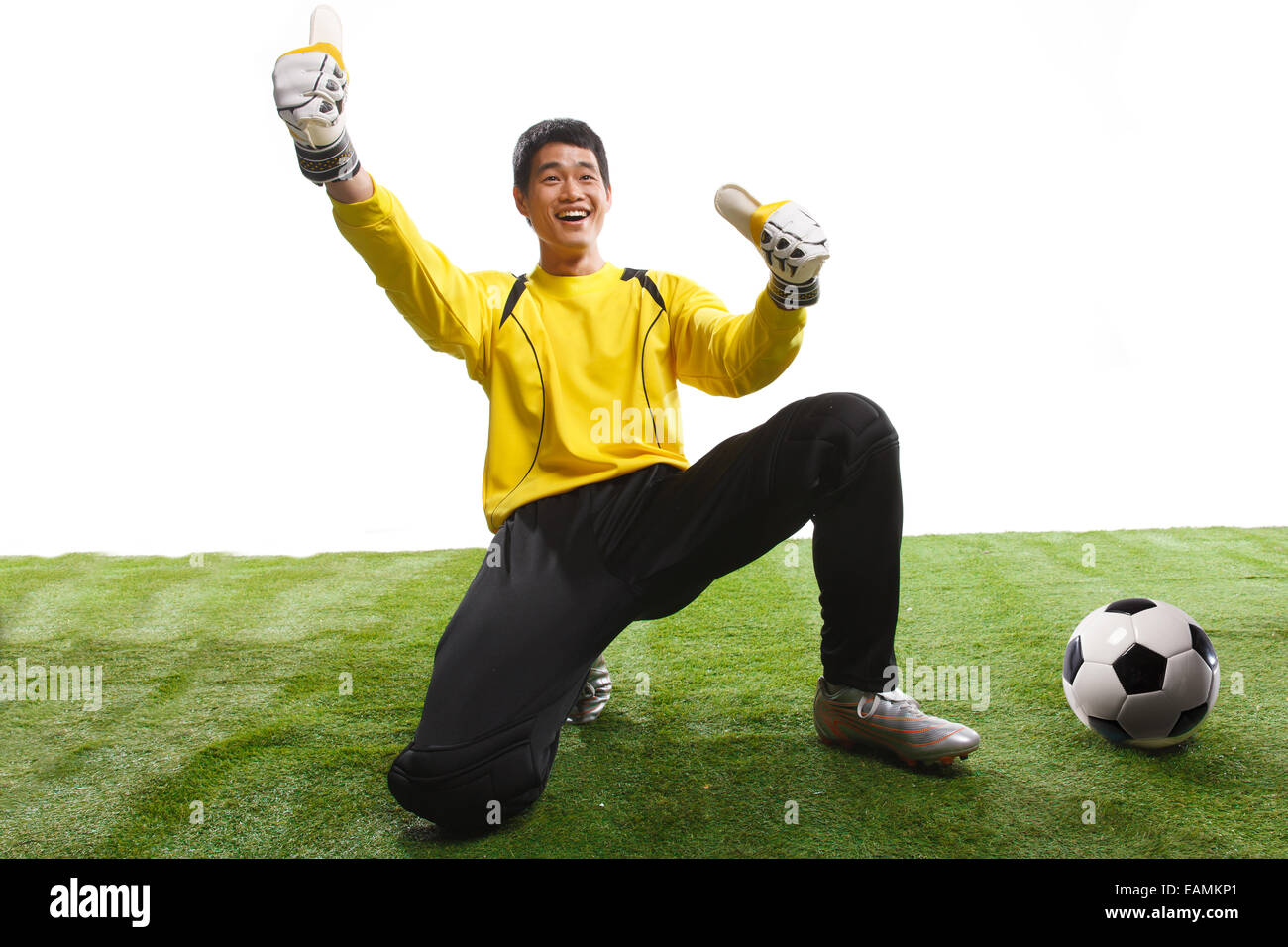 A football player knelt down on the grass gestures Stock Photo - Alamy