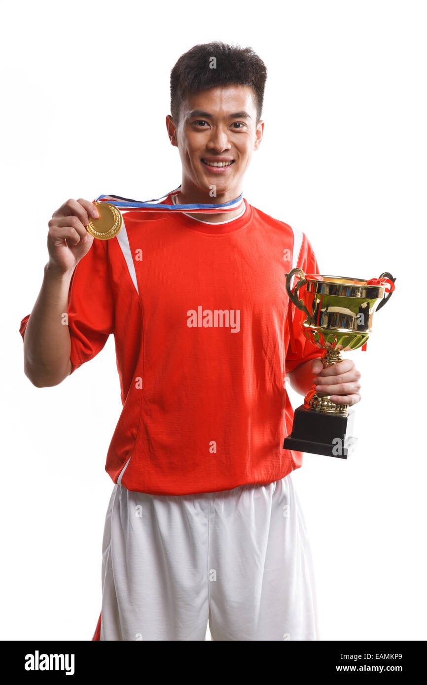 A young player with a trophy and the gold medal Stock Photo - Alamy