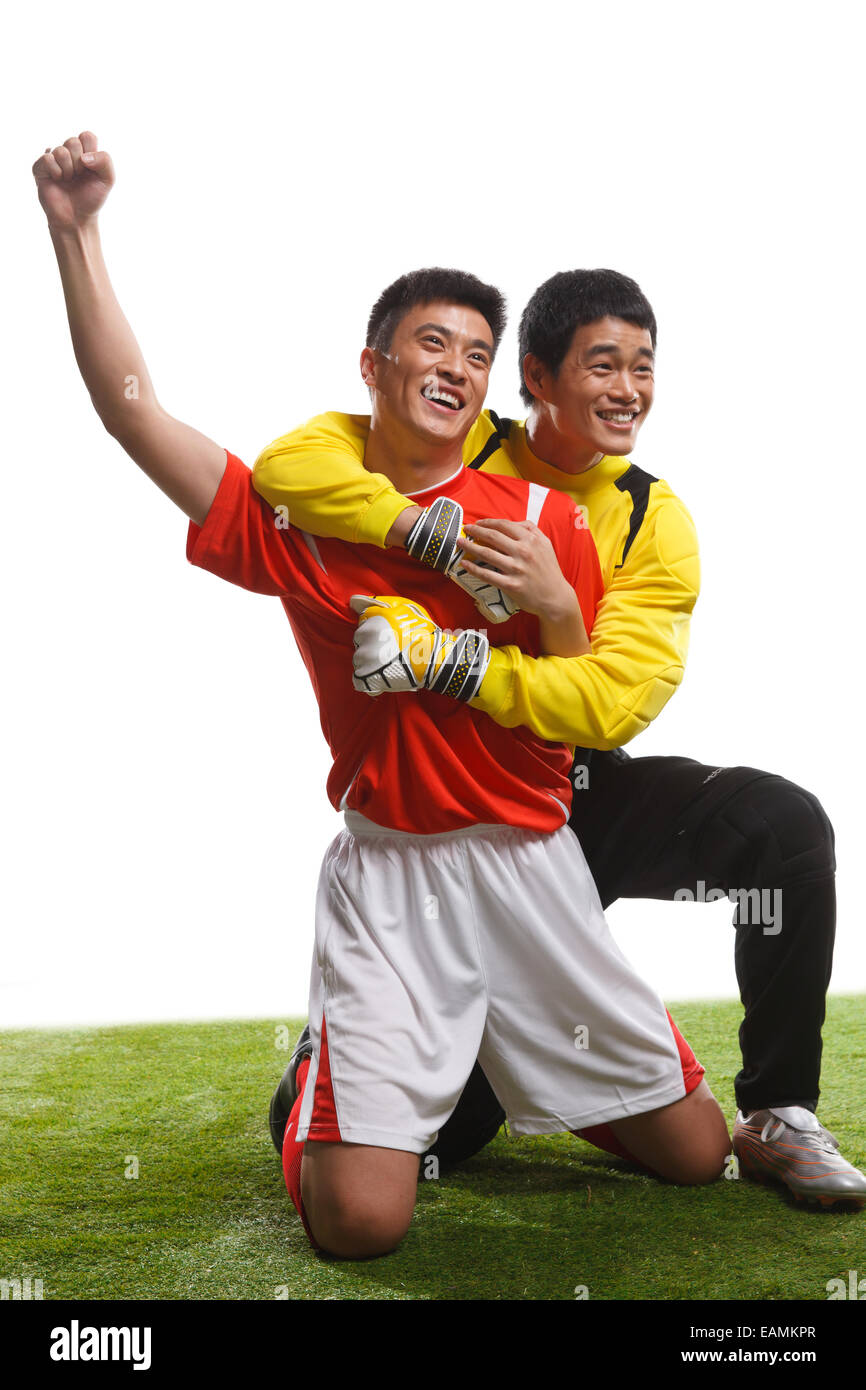 Exciting football player knelt in cheering on the ground Stock Photo ...