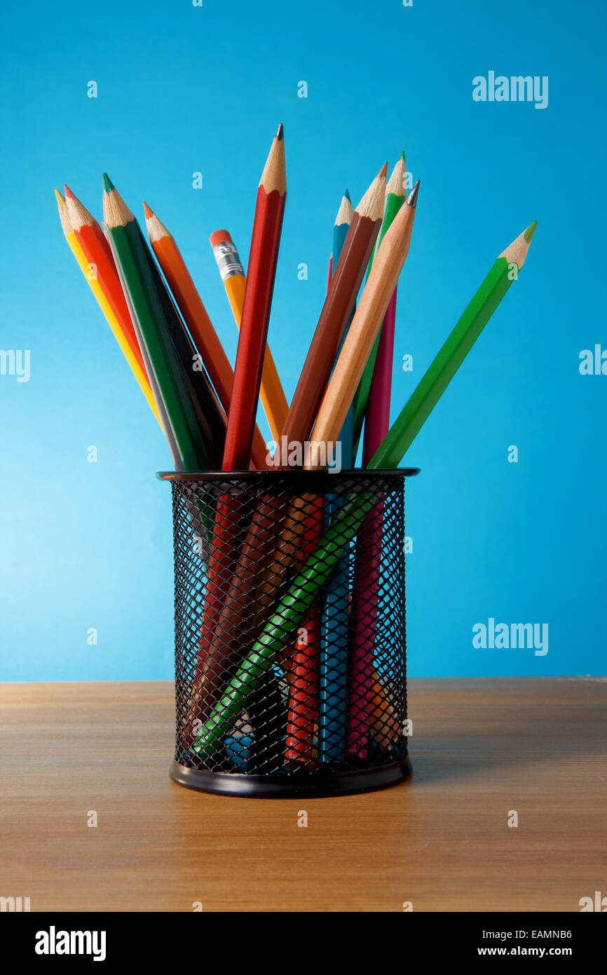 holder basket full of colored pencils standing on green background ...