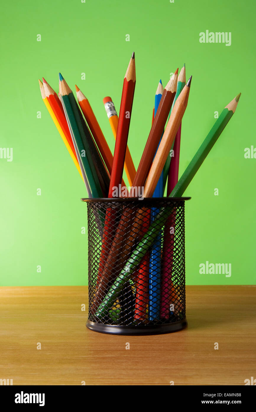 holder basket full of colored pencils on green background Stock Photo ...