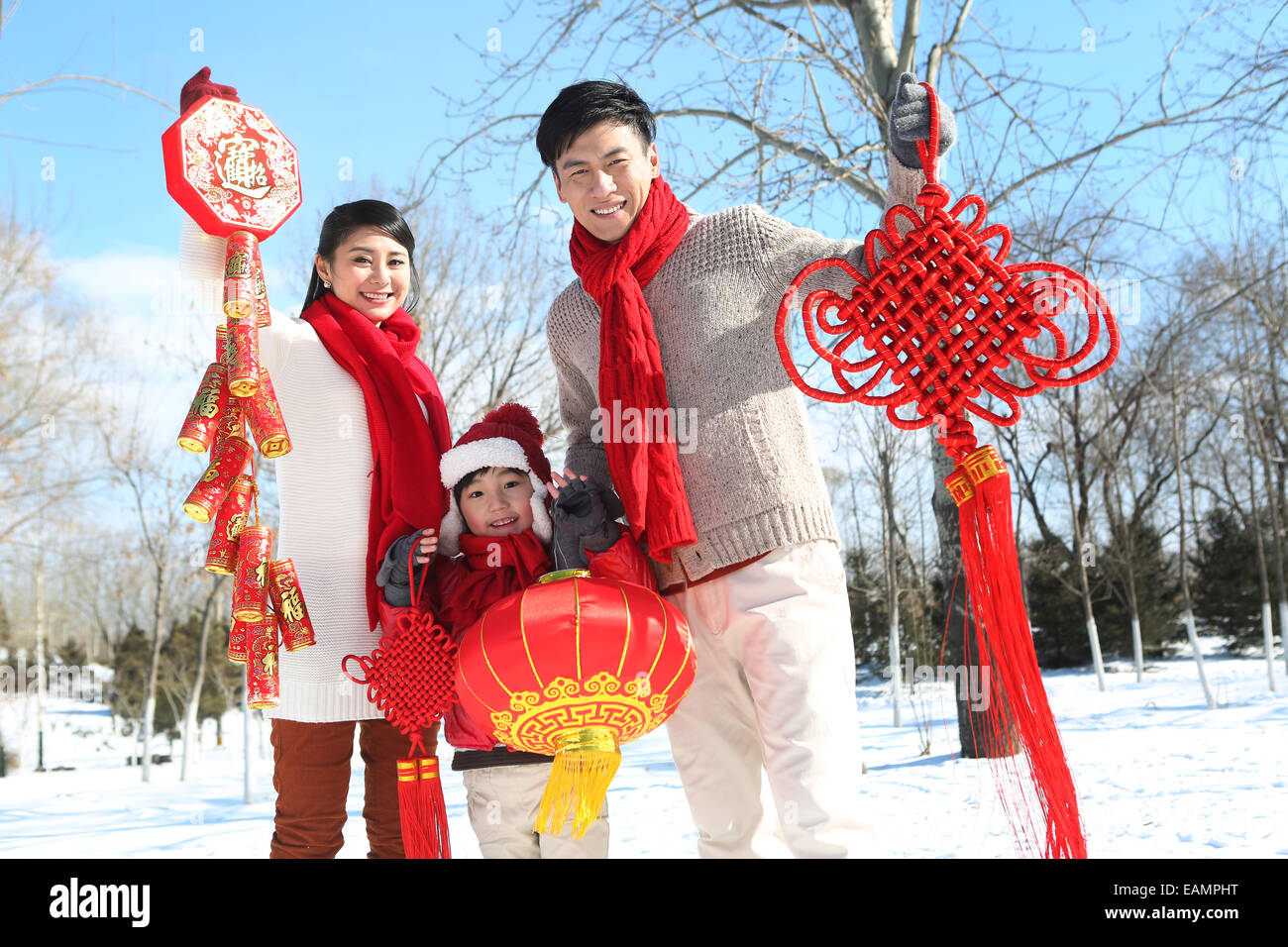 A family of three in the snow with New Year decoration Stock Photo - Alamy