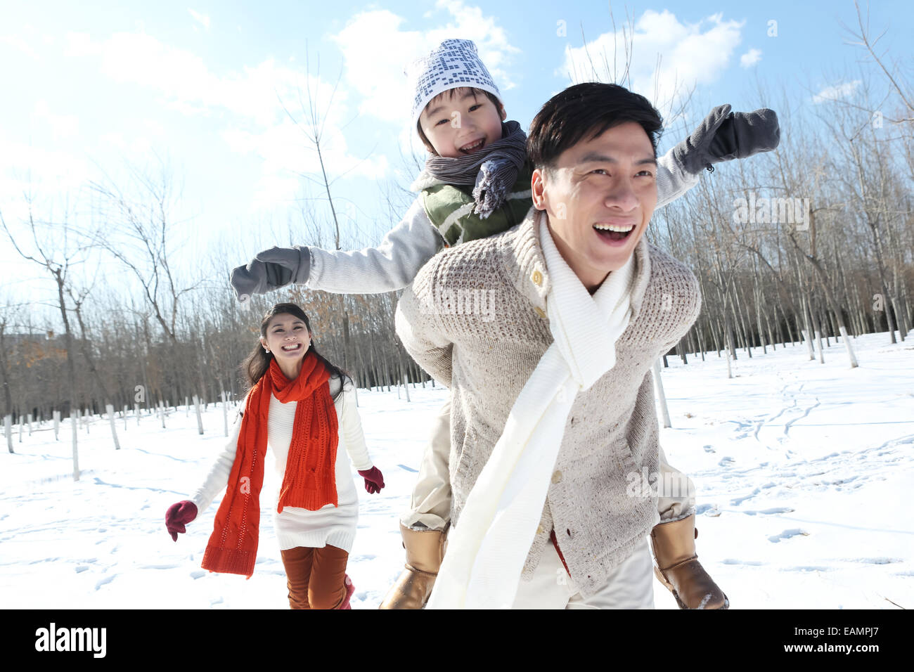 A family of three running in the snow Stock Photo - Alamy