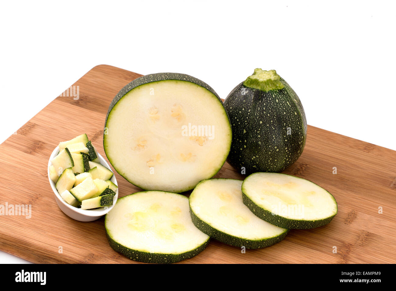 Round Courgettes, Whole, slice on a wooden chopping board. white ...