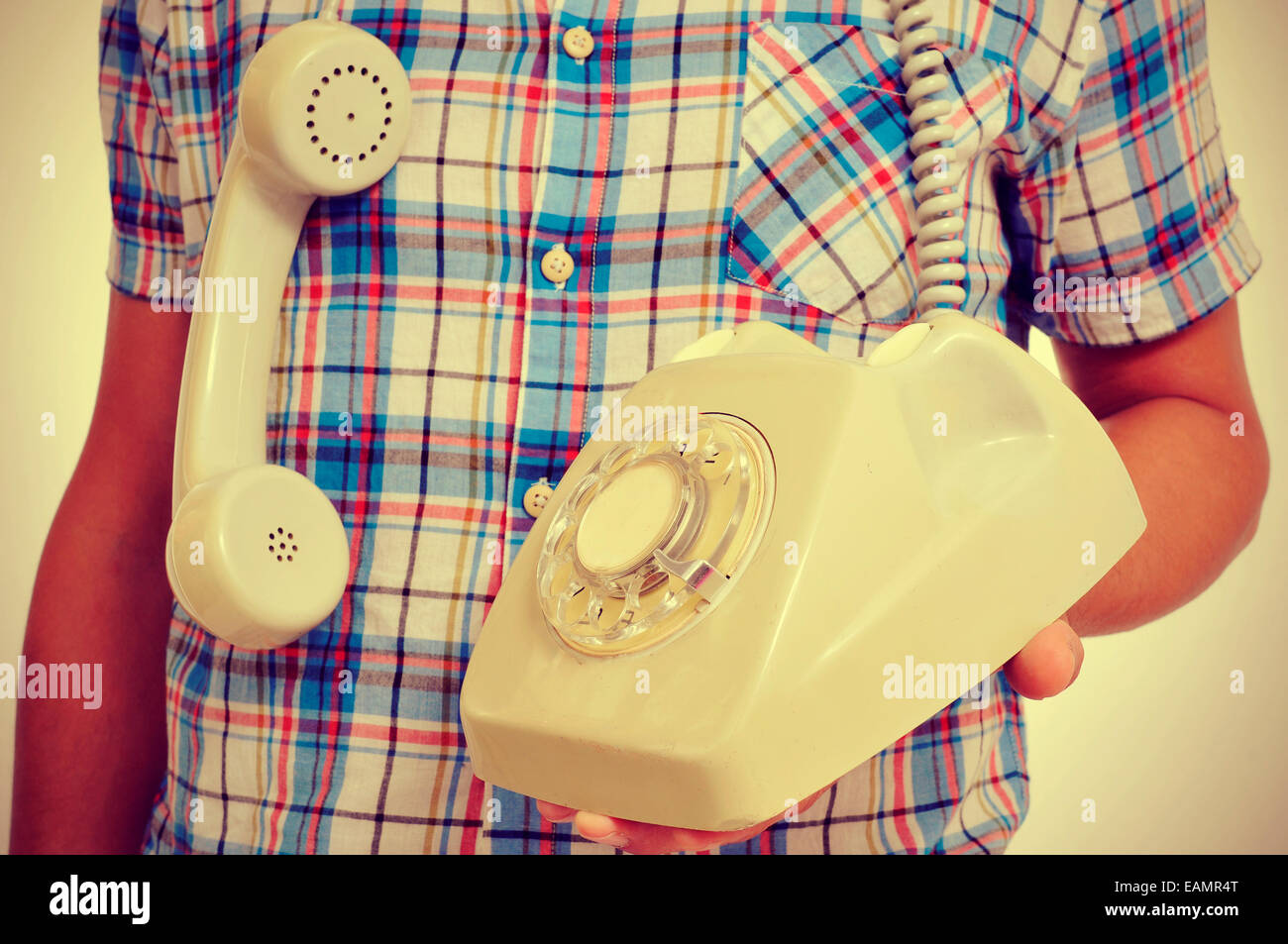 a young man with a rotary dial telephone in his hand, with a retro ...