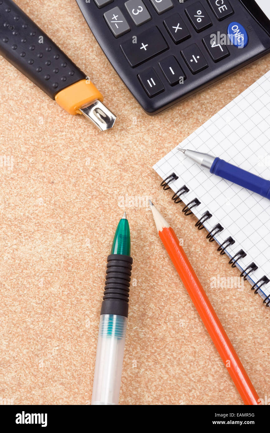 pen, pencil and paper knife with checked notebook on wood texture Stock ...
