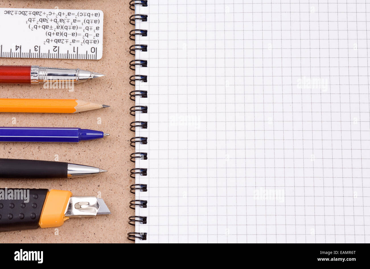pen, pencil and paper knife with checked notebook on wood texture Stock ...