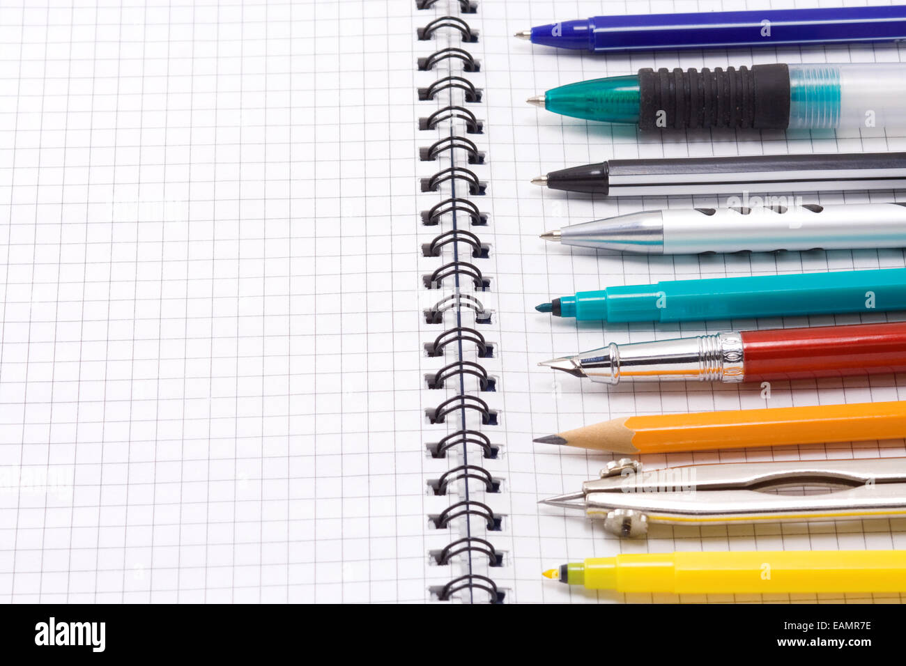 pen, pencil and felt pen on checked notebook Stock Photo - Alamy