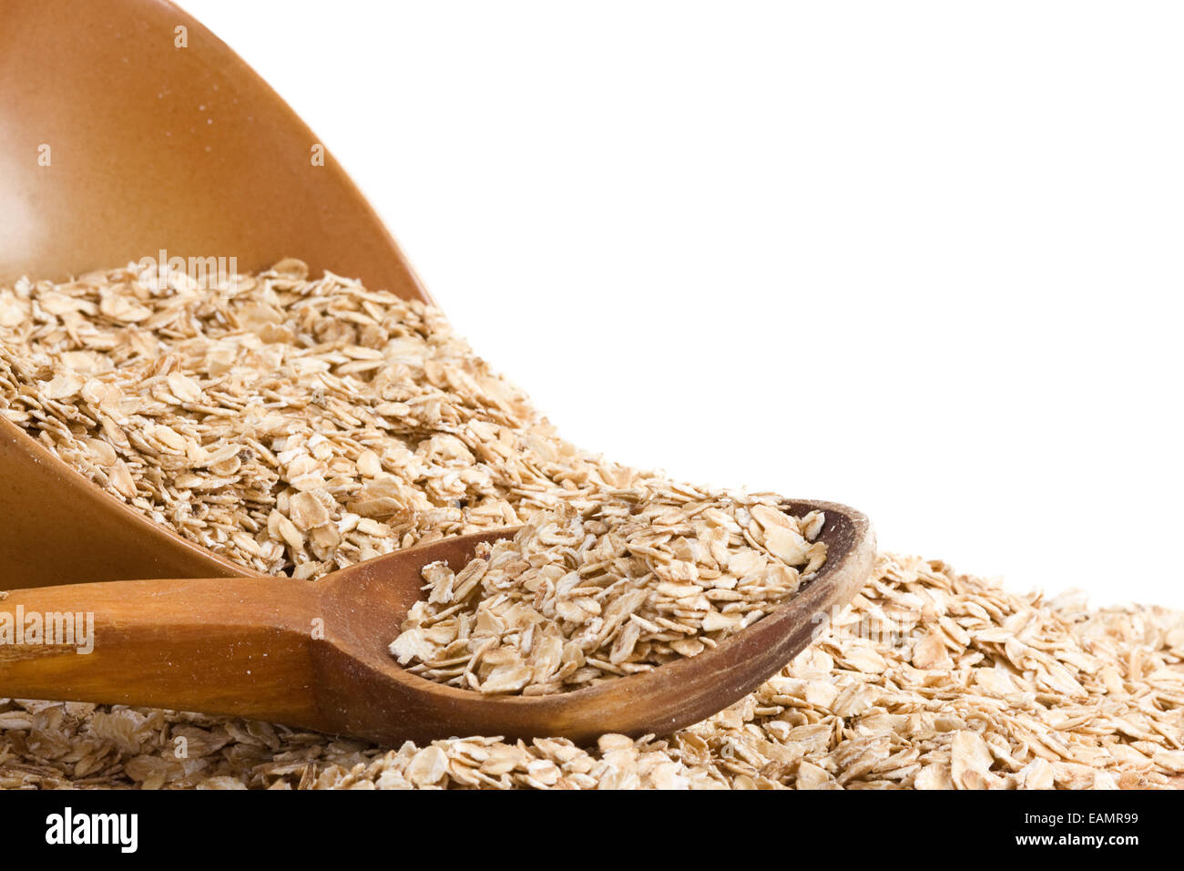 oat flakes and wood spoon in ceramic plate isolated on white background ...