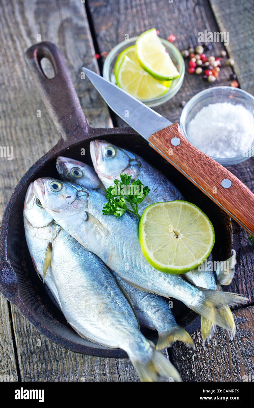 raw fish with lemon on the pan and on a table Stock Photo - Alamy