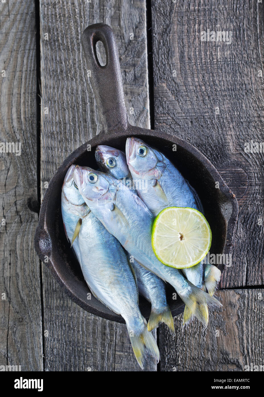 raw fish with lemon on the pan and on a table Stock Photo - Alamy