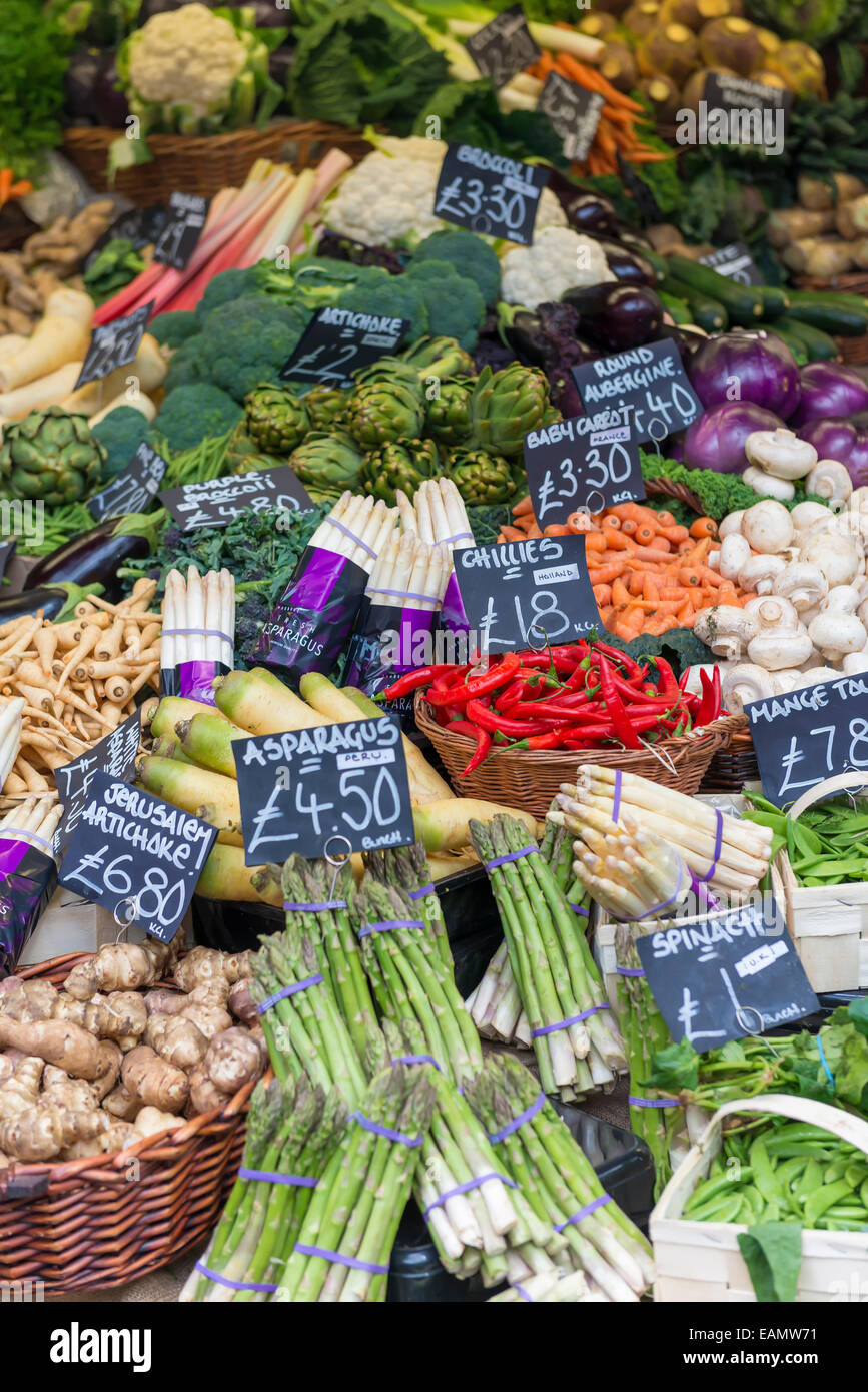 A selection of vegetables priced up and displayed on a market stall ...