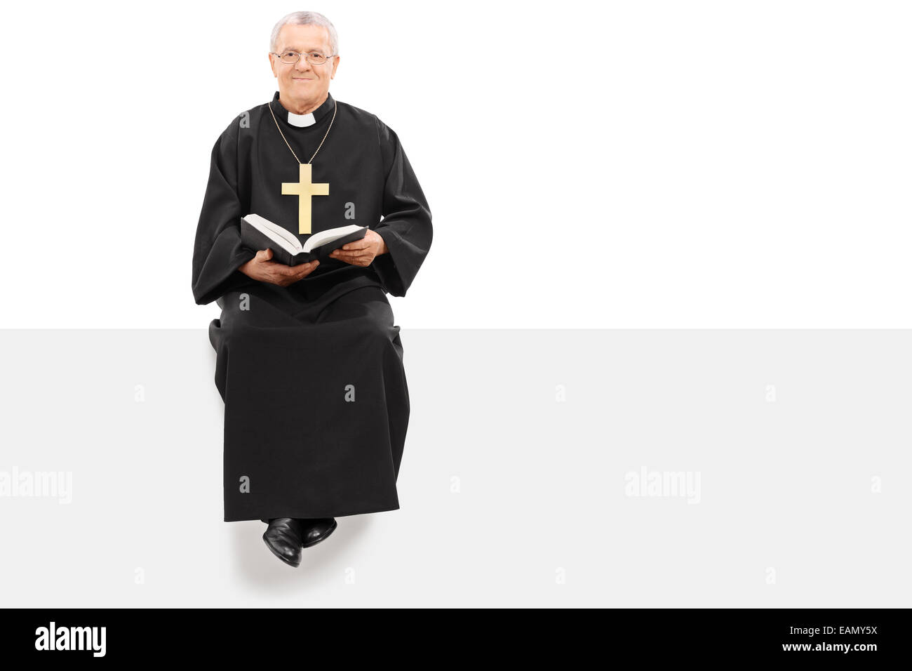 Christian priest reading the bible seated on panel isolated on white ...