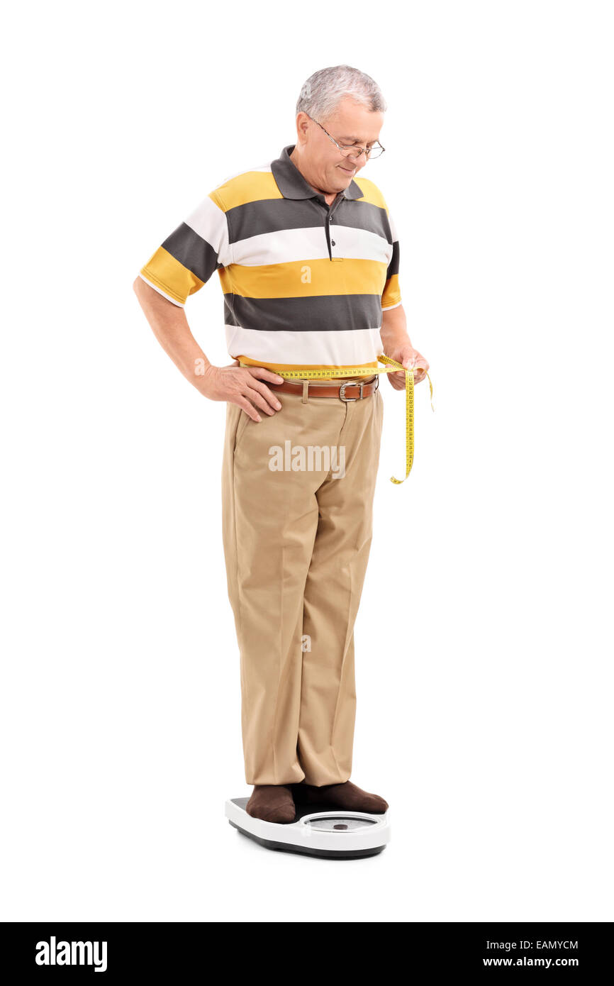 Mature man measuring his waist and standing on a weight scale isolated ...