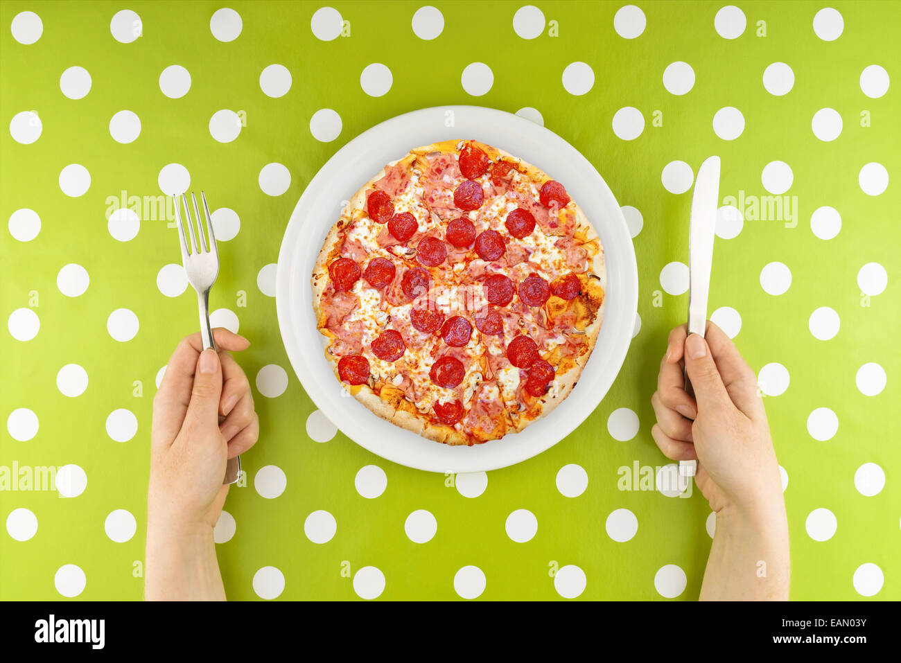 Woman eating pizza. Caucasian Female hands at dinner table holding fork ...