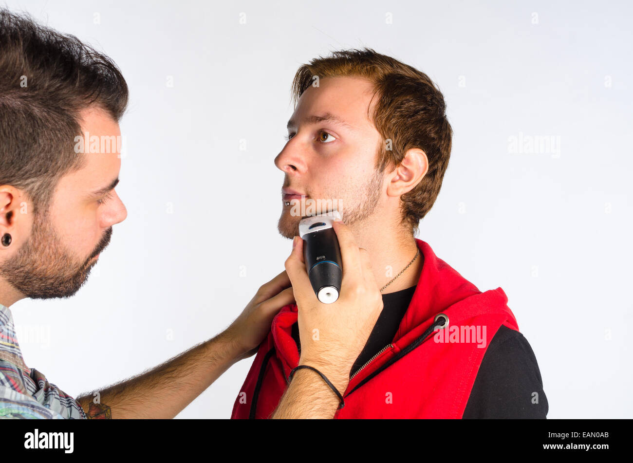 Barber trimming a beard with an electric razor Stock Photo - Alamy