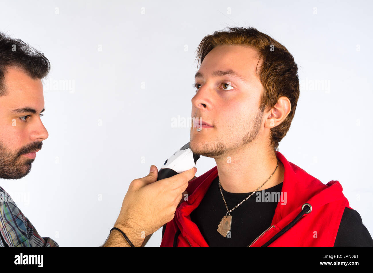 Barber trimming a beard with an electric razor Stock Photo - Alamy