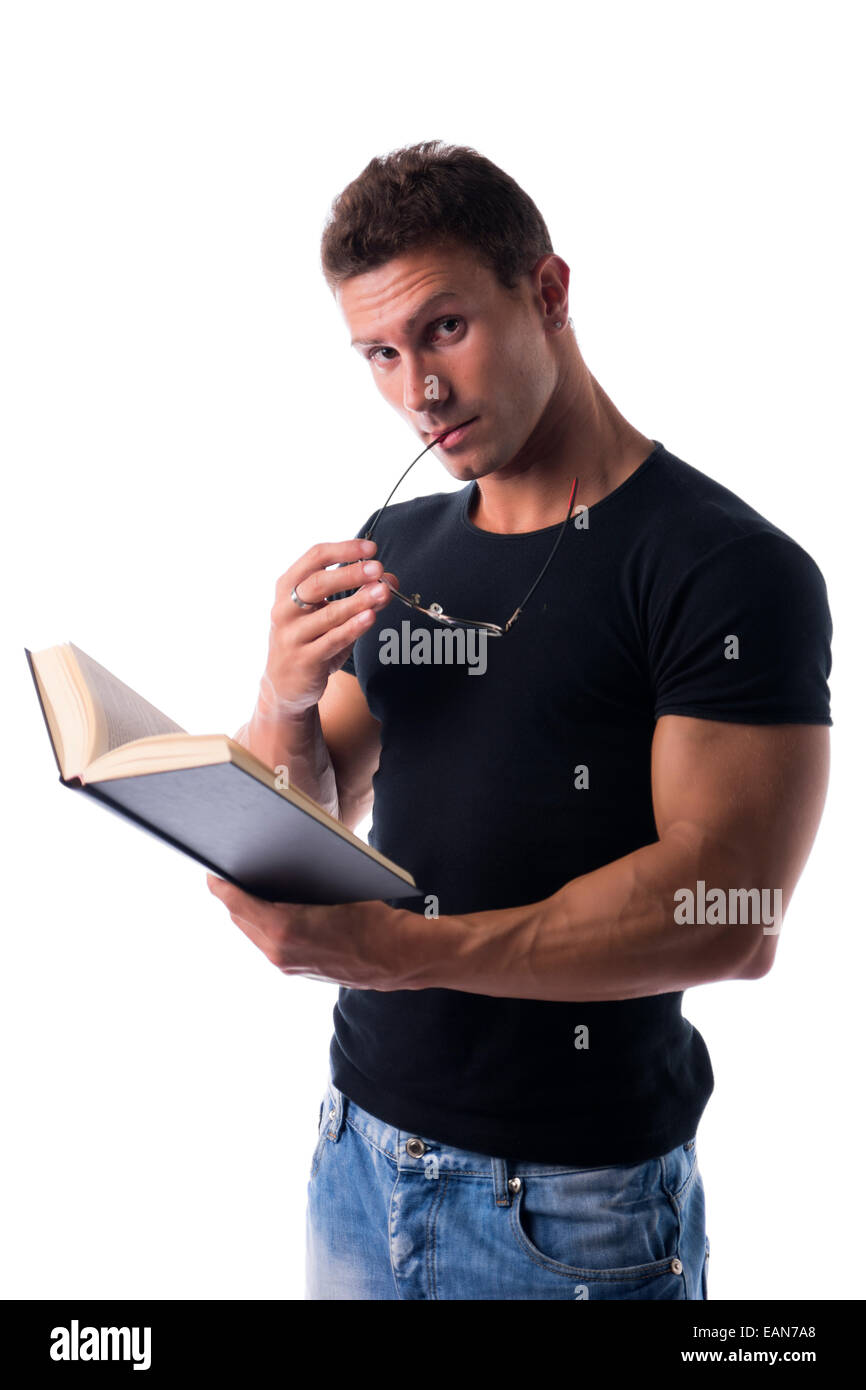 Attractive and athletic young man reading book, looking at camera ...