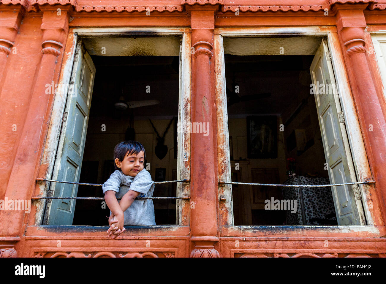 A Child Watches The World Go By From His House Overlooking The Street ...