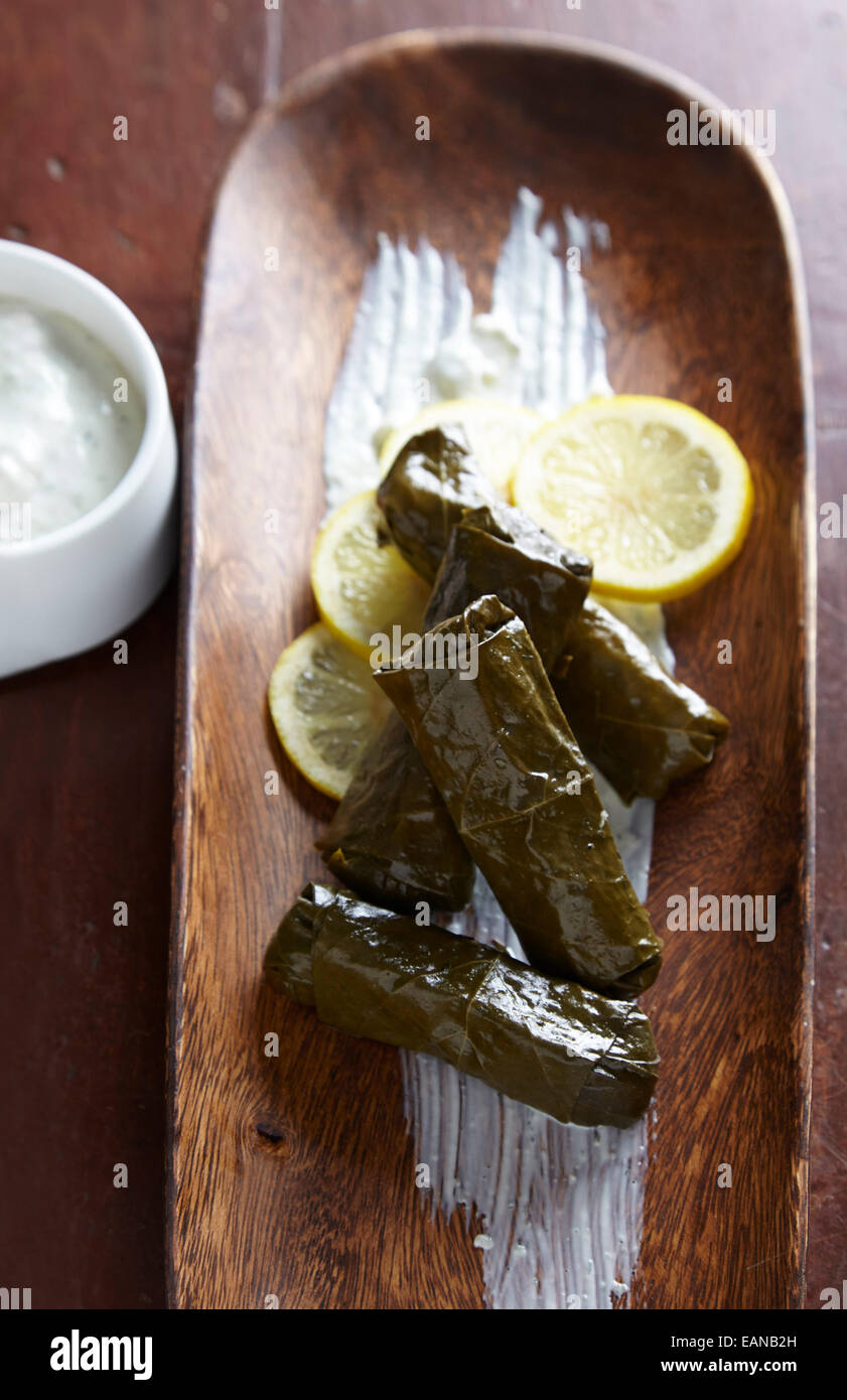 Sarma Dolma grape leaves with yogurt and lemon in a wooden dish on a ...