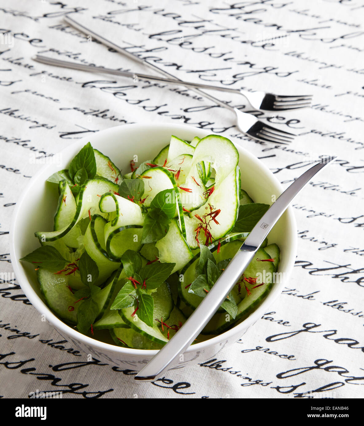 cucumber salad with decorative cut in a dark plate on a white with ...