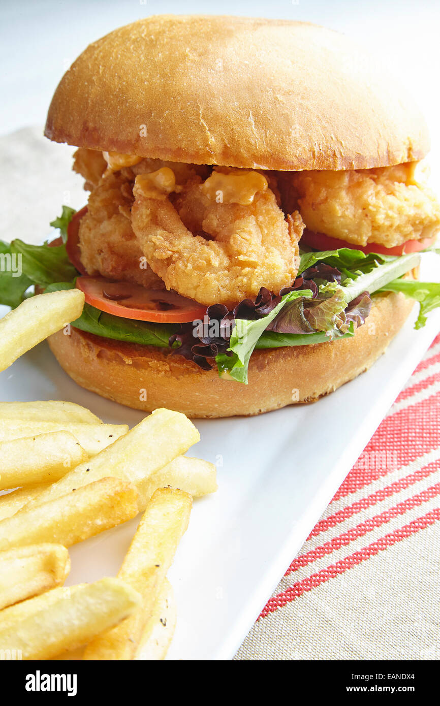 Shrimp Po Boy with french fries on a white plate with red stripe table ...