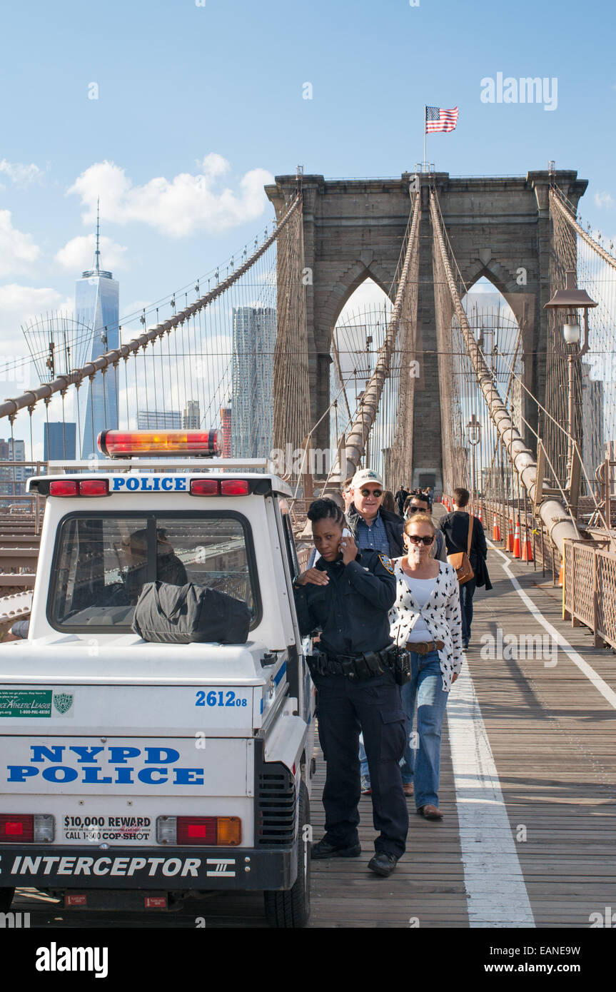 Female police officer using phone on Brooklyn Bridge, Manhattan, New ...