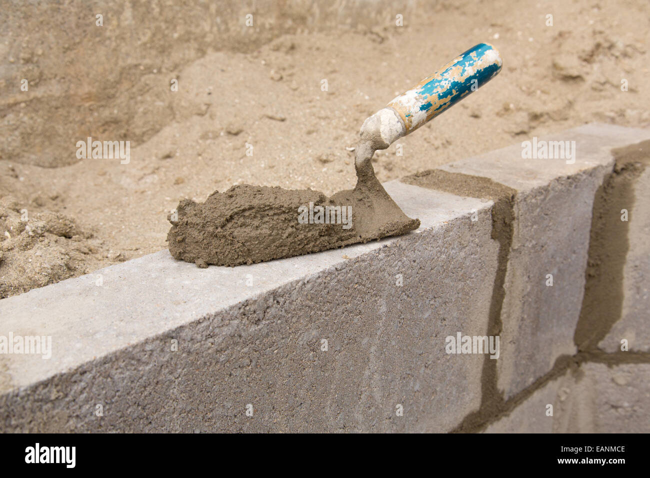 Trowel with concrete on a constructed wall outdoors Stock Photo - Alamy