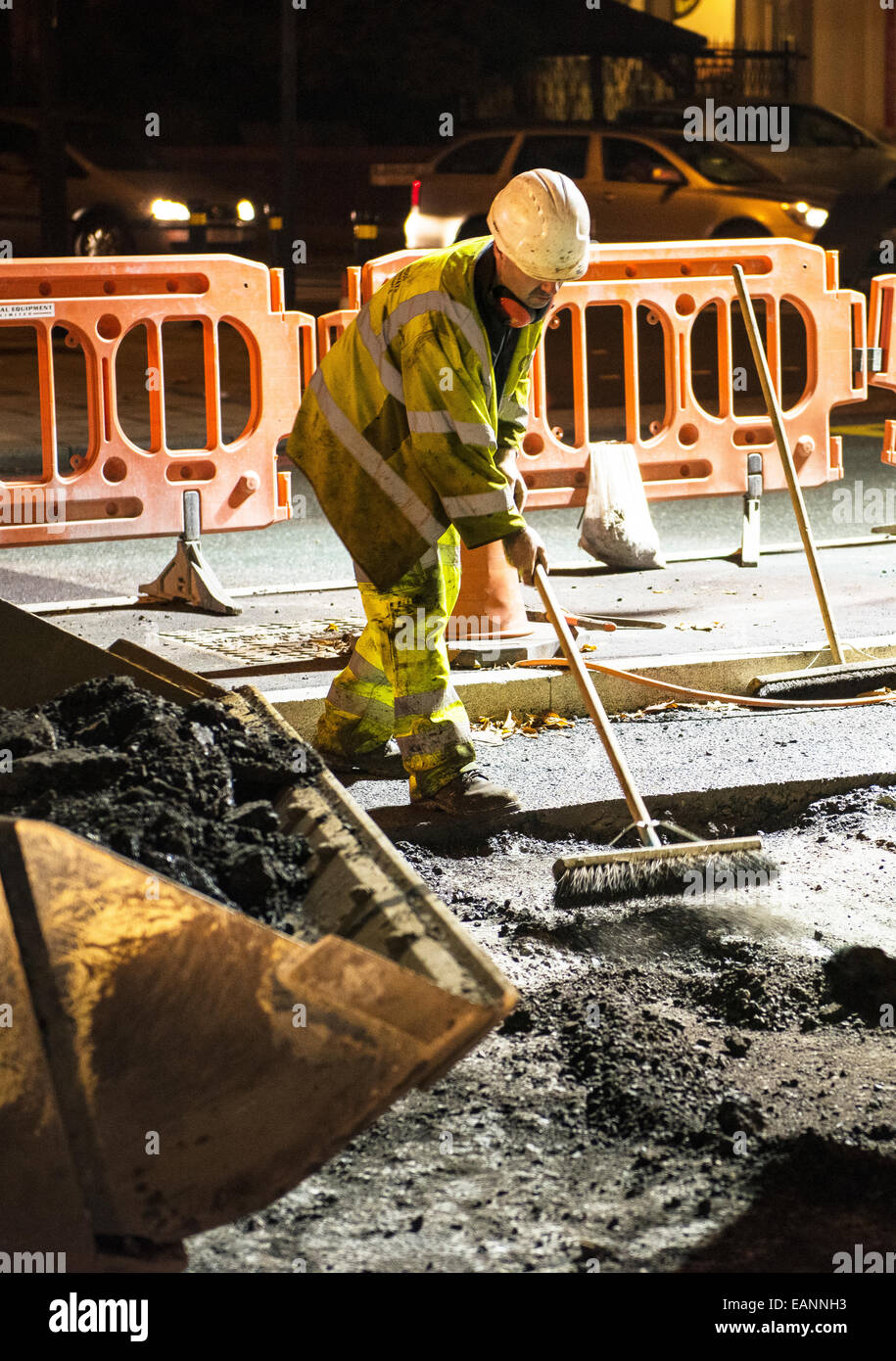 Road worker laying tarmac, night time Stock Photo - Alamy