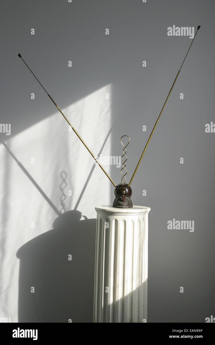 old fashioned rabbit ears antenna on fluted pedestal casts shadow on ...