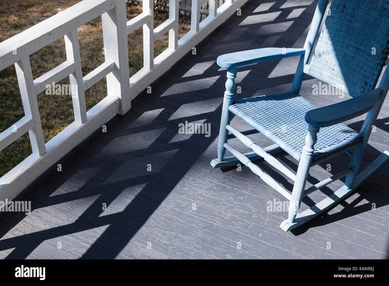shadows of classic porch railing design make pattern on blue porch ...