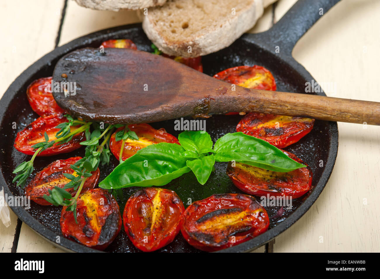oven baked cherry tomatoes with basil and thyme on a cast iron skillet ...