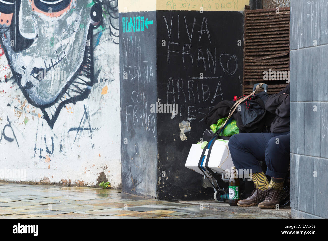 Homeless man sitting in doorway near pro General Franco graffiti in ...