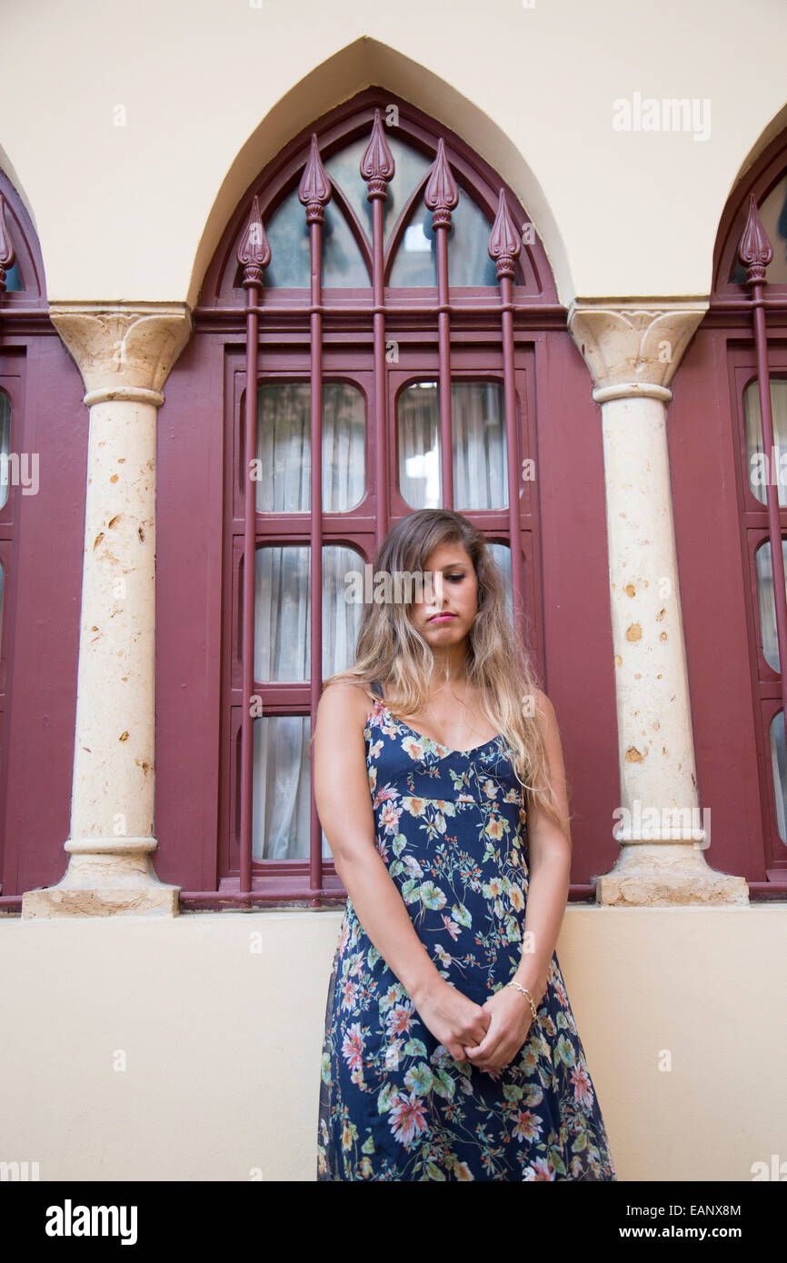 Young woman standing outside a house with arched windows Stock Photo ...