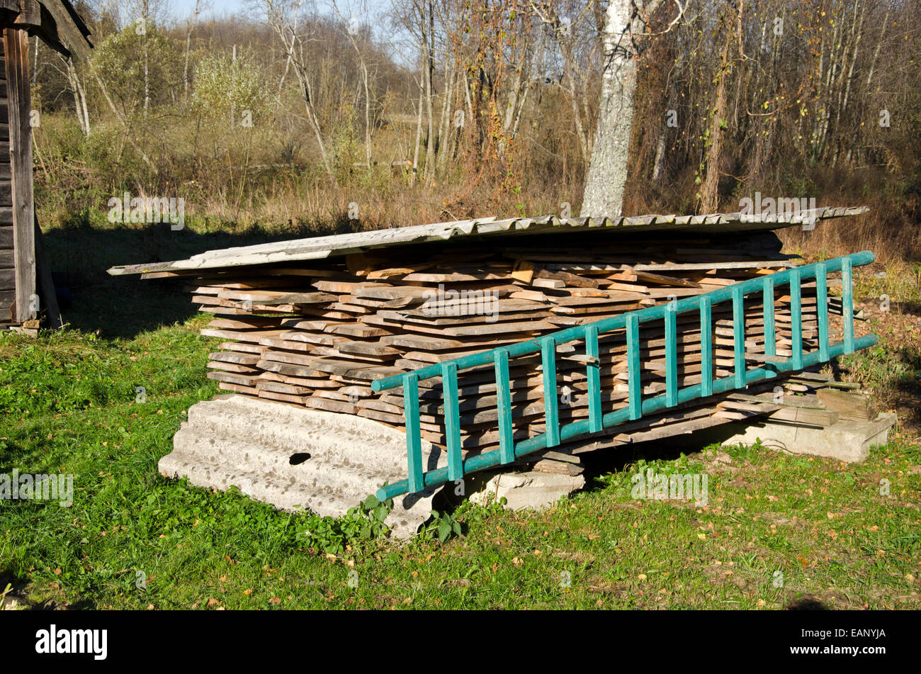 green ladder and wood planks stack in farm yard Stock Photo - Alamy