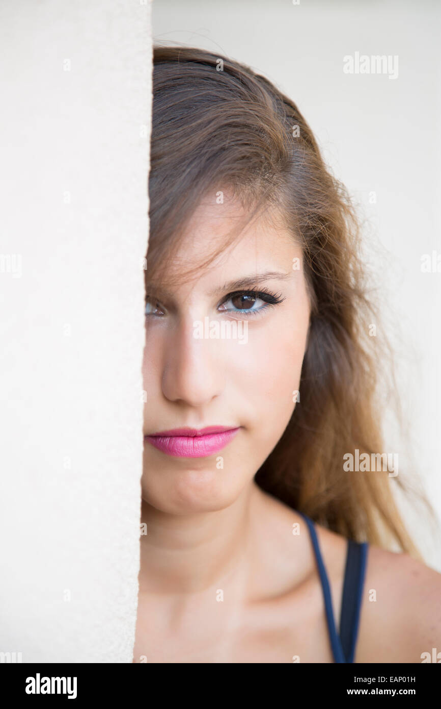 Beautiful young woman peeking Stock Photo - Alamy
