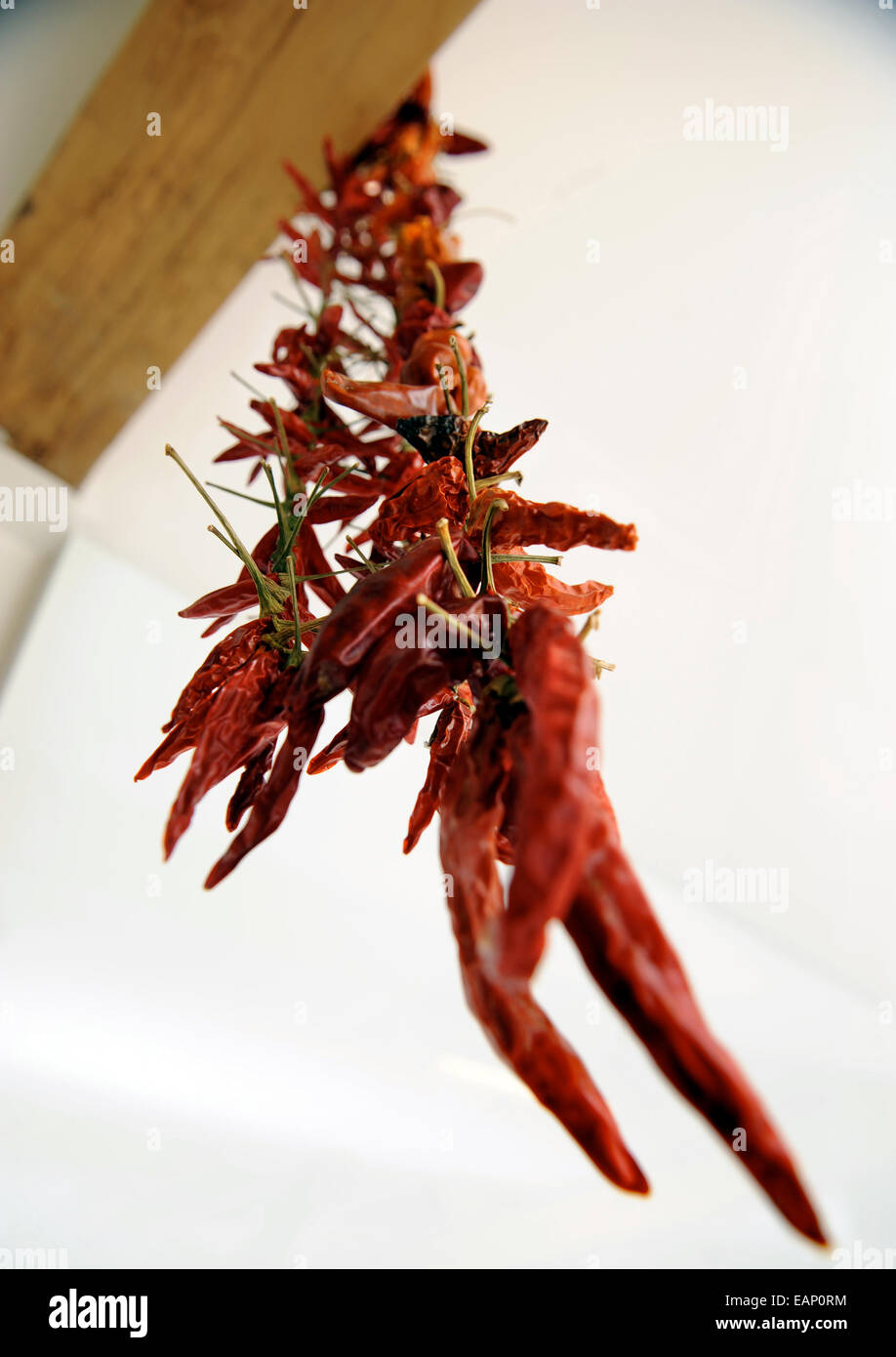 Dried chillies hanging from a beam in a kitchen Stock Photo - Alamy