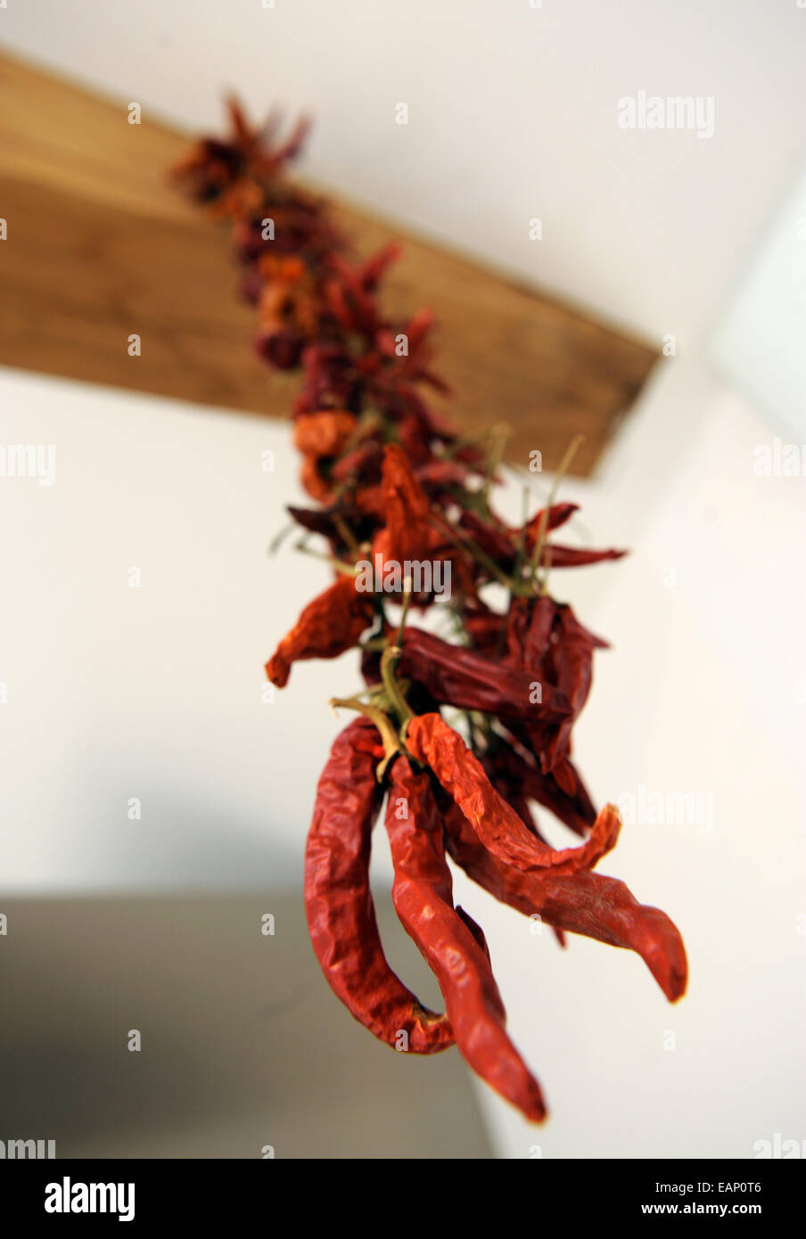 Dried chillies hanging from a beam in a kitchen Stock Photo - Alamy