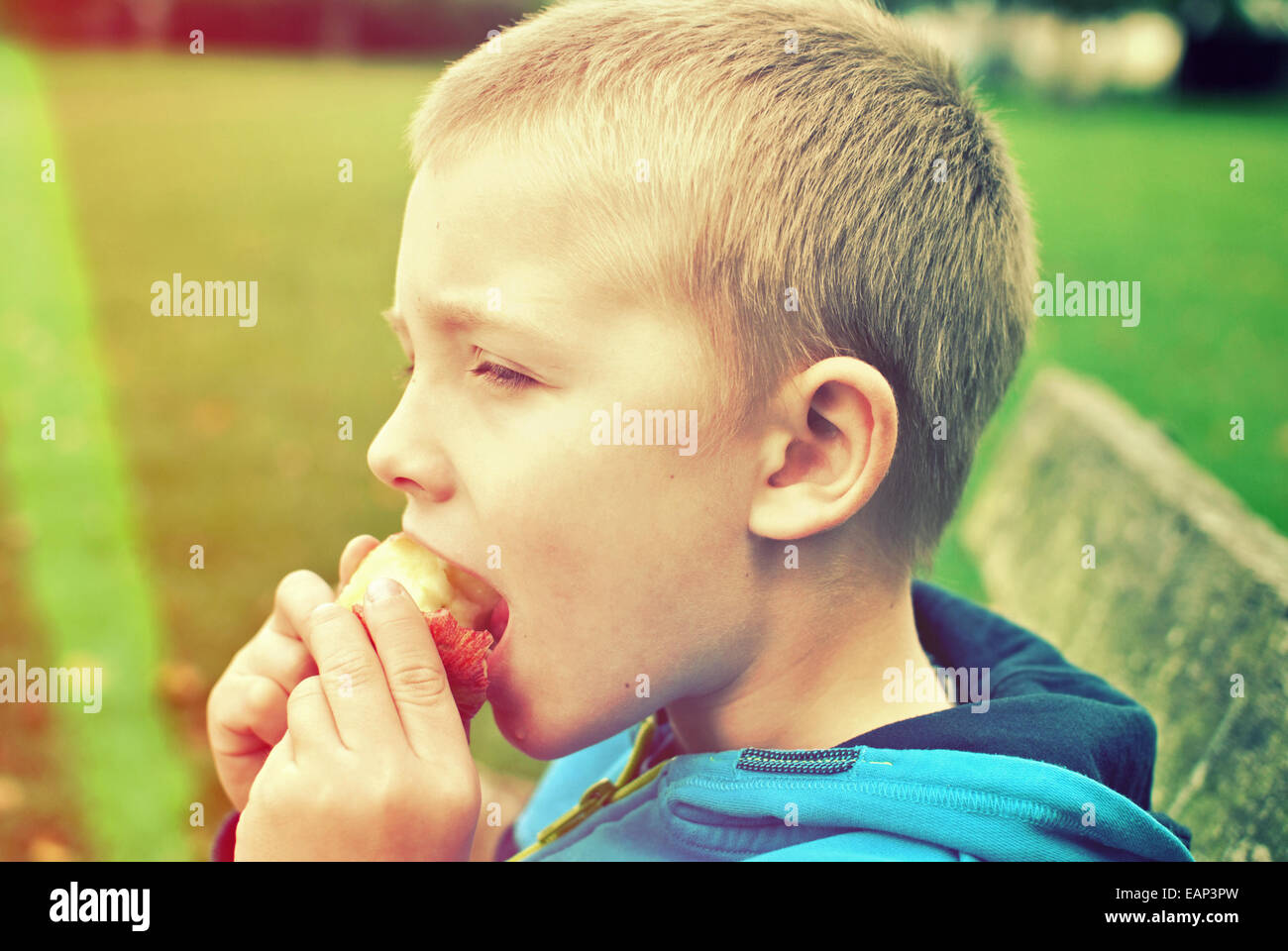 school boy eating apple in the park Stock Photo - Alamy
